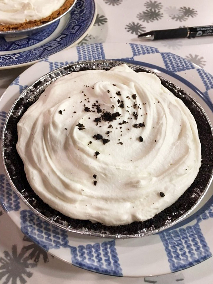 A slice of heaven on a black plate - where cream, chocolate, and crust combine in what can only be described as the dessert equivalent of finding a twenty in your winter coat.