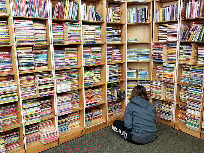 The universal bookstore squat &ndash; the position every serious reader knows well. Bottom shelves always hide the best treasures.