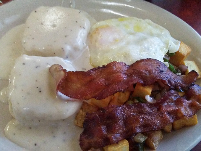 Country gravy blankets this breakfast like Nevada's first winter snow, with bacon standing at attention like it knows it's the star.