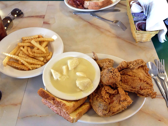 Fried chicken so golden it deserves its own trophy, paired with dumplings that float like clouds in a comfort food heaven.