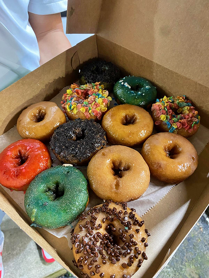 A colorful congregation of fried perfection, each donut a unique personality. The green ones aren't seasick&mdash;they're mint chocolate masterpieces waiting for their moment.