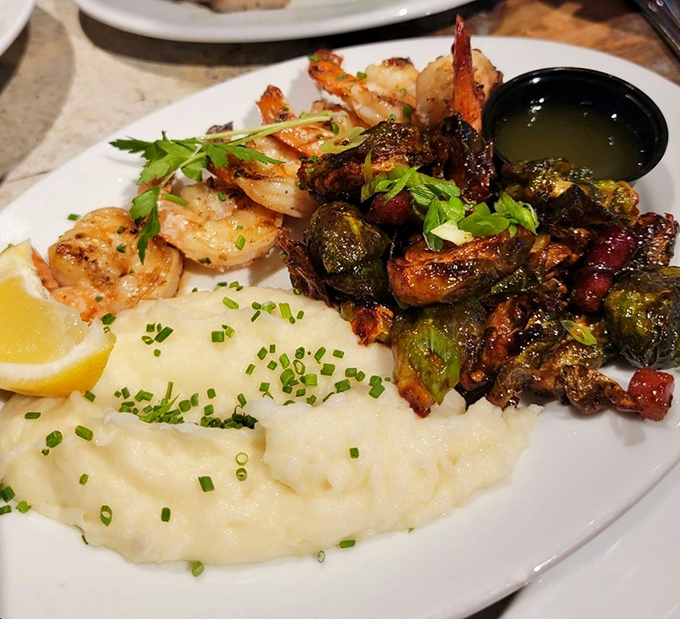 Grilled prawns nestled against creamy mashed potatoes and Brussels sprouts. Proof that seafood and comfort food make beautiful music together.