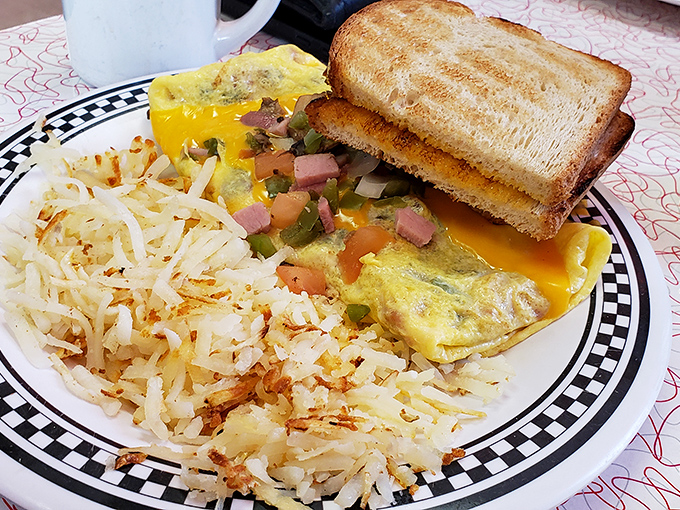 An omelet that's clearly been to college, surrounded by perfectly crisped hash browns. This plate has more layers than your favorite novel.