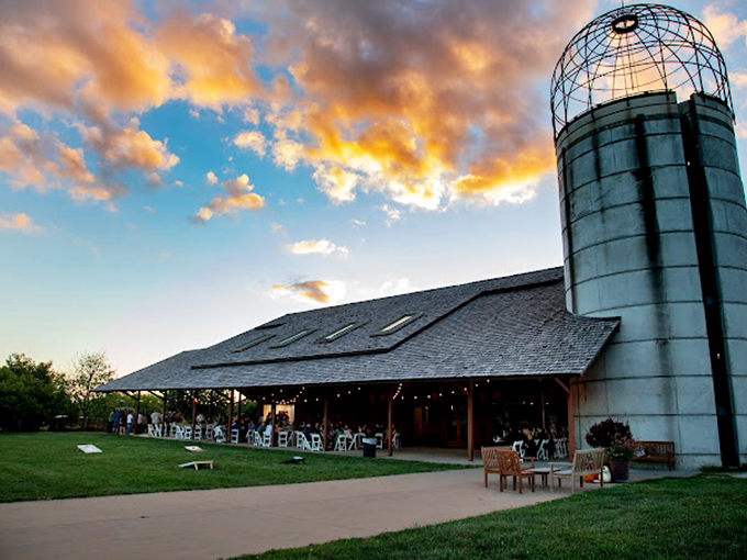 The Missouri Barn and silo at sunset transform from agricultural architecture into a golden-hour gathering place for garden enthusiasts.