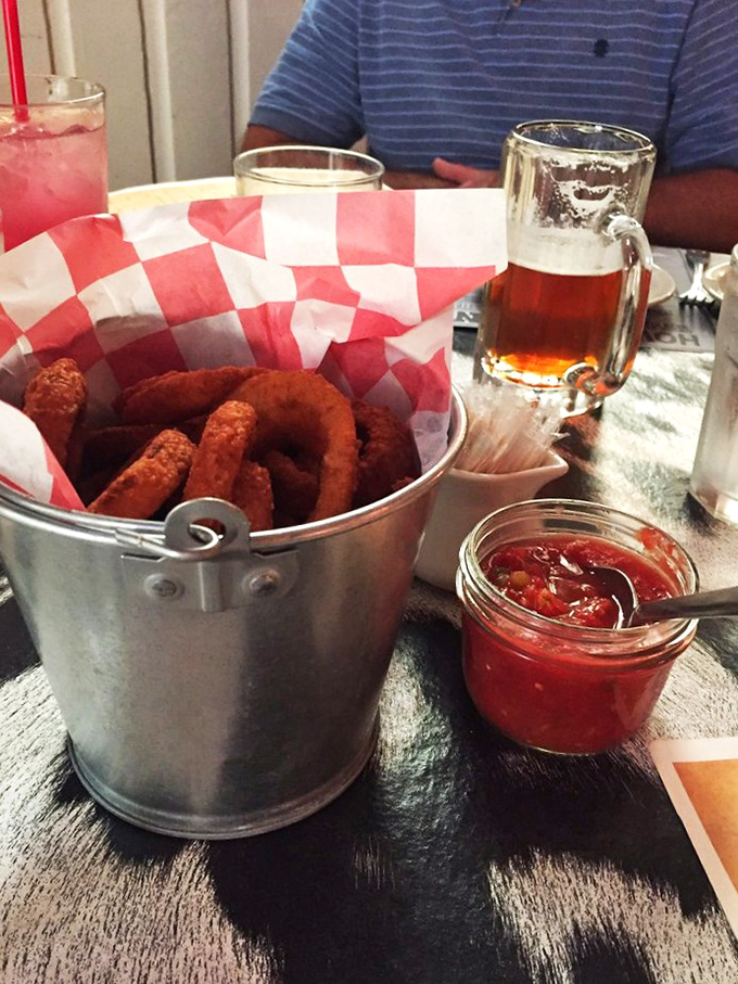 Onion rings served in a metal bucket&mdash;because paper baskets are for amateurs. That house-made salsa isn't just a condiment, it's a revelation.