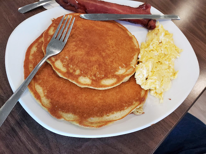 Pancakes so perfectly golden they look like they've been sunbathing on a Virginia beach, with eggs and bacon playing supporting roles in this breakfast symphony.