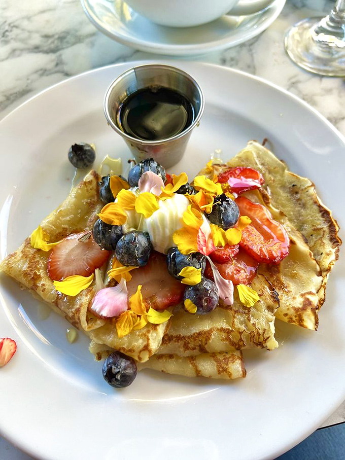 Pancakes adorned with edible flowers and fresh berries&mdash;because sometimes breakfast should look like it belongs in both a museum and your mouth.