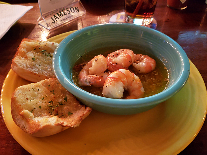 Butter-bathed shrimp lounging in their golden hot tub, flanked by garlic bread ready for the inevitable sauce-sopping mission.