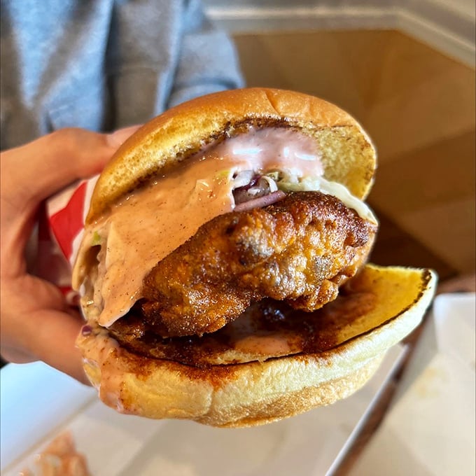 The Sando in all its glory&mdash;a masterpiece of architecture where crispy chicken, sauce, and soft bun achieve perfect structural and flavor harmony.