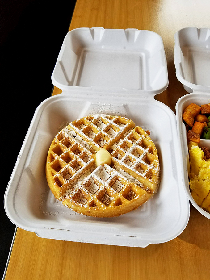 A waffle so perfectly golden it deserves its own spotlight, with butter melting into those crispy squares like nature intended.