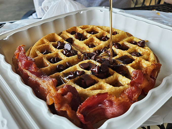 Not just any waffle&mdash;a masterpiece bordered by bacon and baptized with maple syrup, proving breakfast can indeed be art.