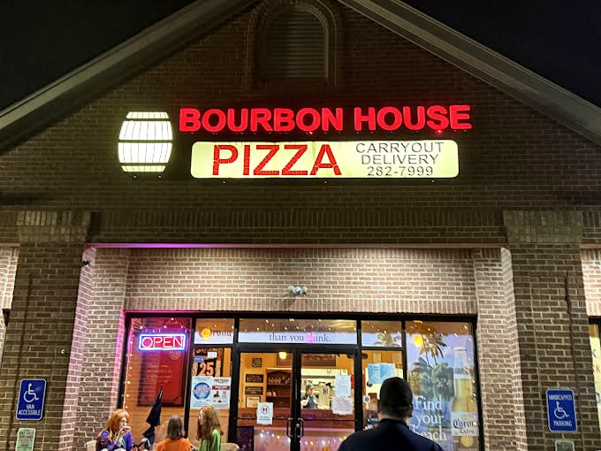 Bourbon House Pizza's illuminated sign glows like a beacon for hungry souls seeking cheesy salvation.