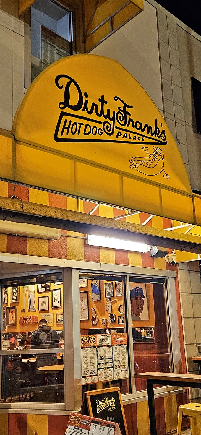 The nighttime glow of Dirty Frank's window reveals a hot dog palace where creativity and comfort food have a delicious affair.