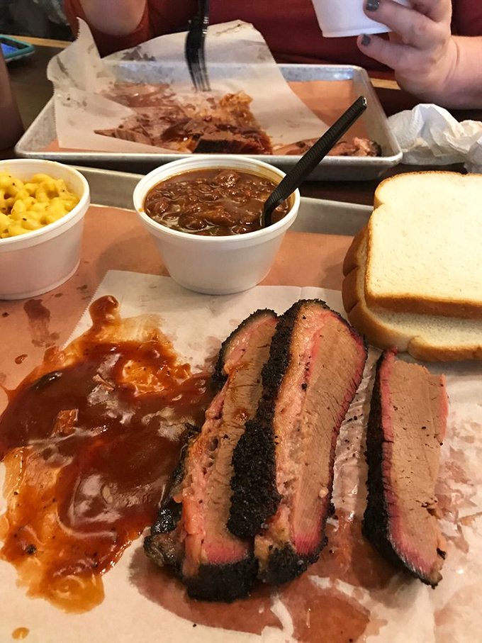 Brisket bathing in sauce with mac and cheese standing by. This tray represents what happiness looks like in solid form&mdash;no filter needed.