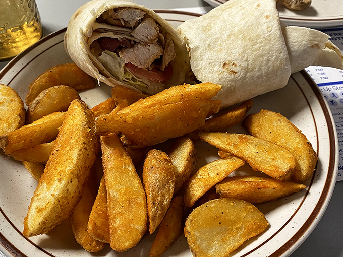 JoJo potatoes stealing the spotlight from a wrap that's packed tighter than a college kid's weekend suitcase. Golden, crispy potato perfection.