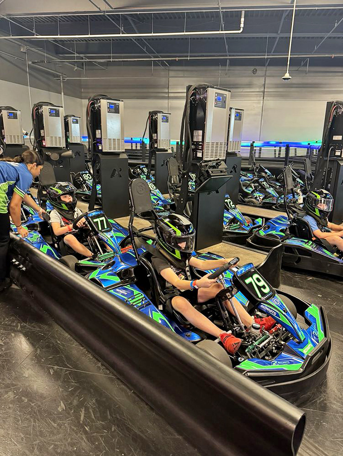 The starting grid awaits as electric karts stand charged and ready. Each numbered chariot promises three minutes of consequence-free speed.