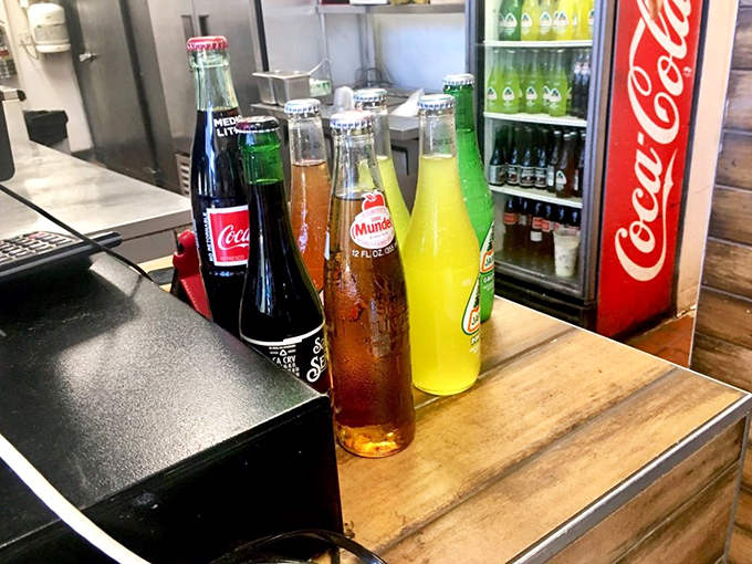 Mexican sodas lined up like colorful soldiers ready for duty. These aren't just beverages—they're liquid companions to cut through the richness of your meal.