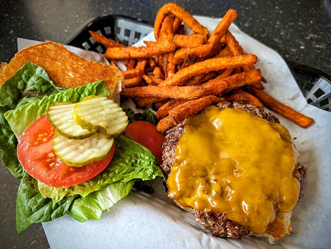 This isn't just a burger&mdash;it's a masterpiece with melted cheese cascading down the sides. Those sweet potato fries are the perfect supporting cast.