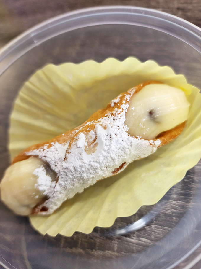 The cannoli&mdash;crisp shell, creamy filling, and a dusting of powdered sugar. Three simple elements that create pure dessert magic.