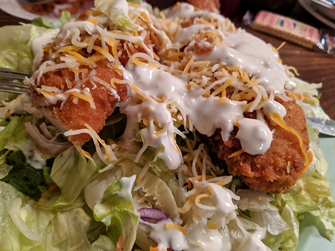 Who knew fried chicken could go formal? Here it dresses up atop fresh lettuce with a creamy drizzle and cheese confetti.