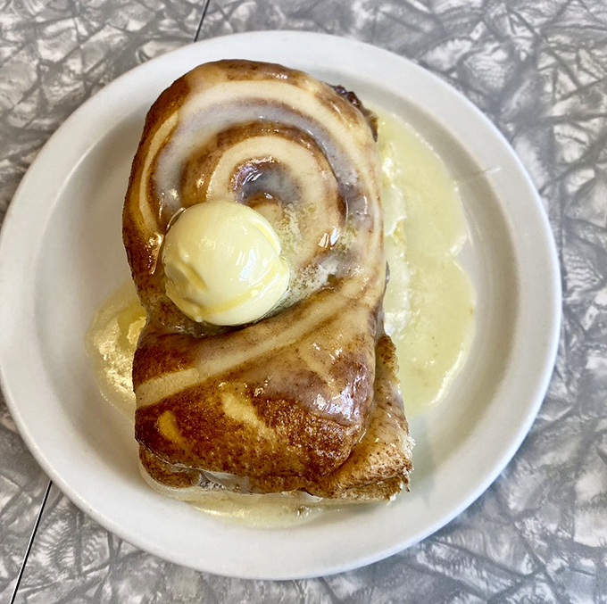 The cinnamon roll sits in a pool of butter like a throne, topped with a melting pat of gold&mdash;breakfast royalty if ever there was one.
