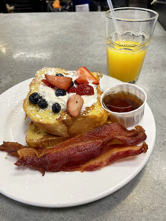 French toast that's dressed for success—berries, cream, and bacon that's achieved that perfect crisp. This isn't breakfast; it's morning theater on a plate.