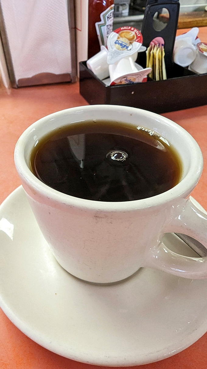 The unassuming diner mug holds the elixir of morning ambition &ndash; straightforward coffee that doesn't need a fancy Italian name to get the job done.