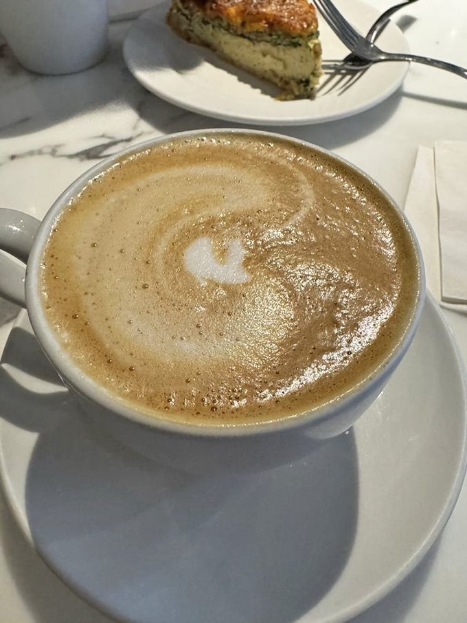 Coffee art so beautiful you almost feel guilty disturbing it. Almost. The latte's microfoam canvas pairs perfectly with whatever pastry awaits.