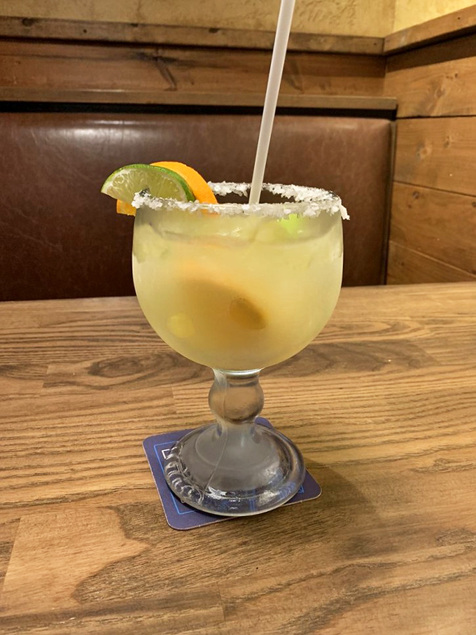 The margarita arrives like a vacation in a glass, with salt-rimmed promises of relaxation after a long Arkansas day.