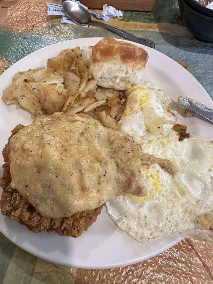 Country fried steak with gravy that cascades like a waterfall of comfort, alongside eggs that know exactly what side they're on.