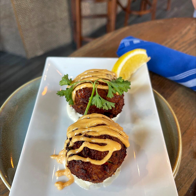 Crab cakes that would make Baltimore jealous. Perfectly golden, minimal filler, and that drizzle of aioli&mdash;culinary architecture at its finest.