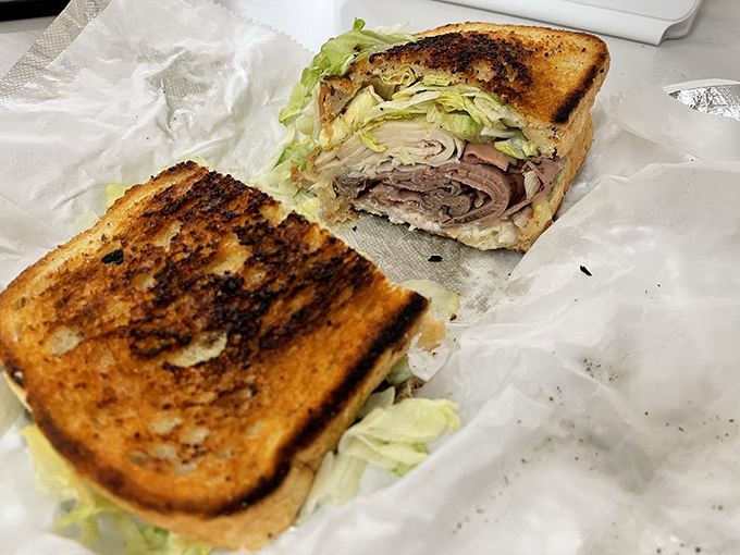 Two perfectly toasted slices of bread barely containing what appears to be a meat department's worth of delicious protein.