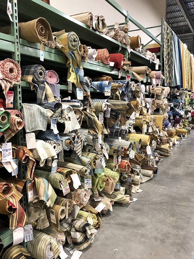Fabric rolls standing at attention like textile soldiers, each one ready to transform your tired furniture into conversation pieces.