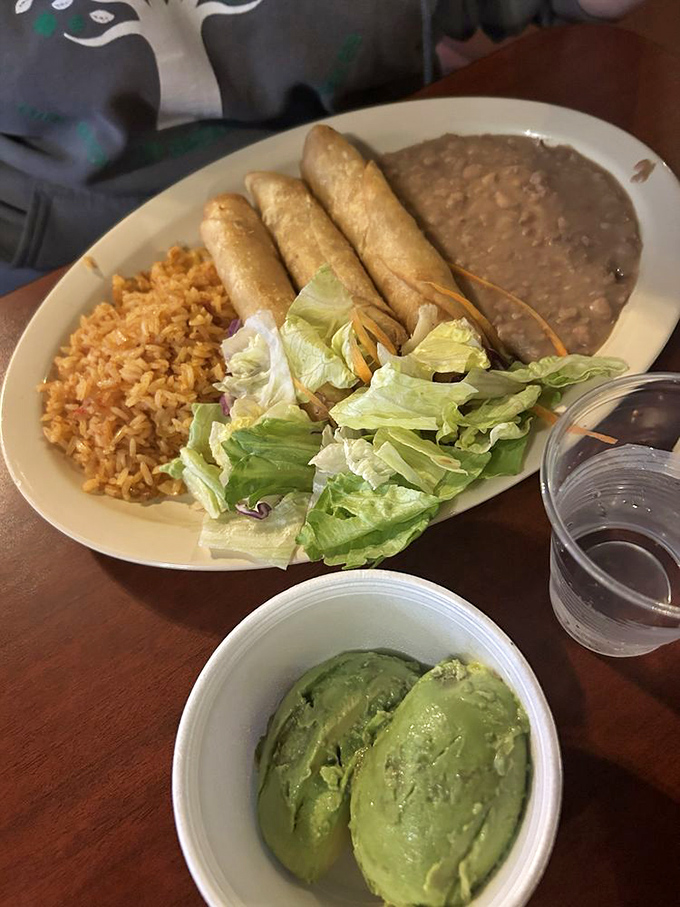 Crispy flautas lined up like delicious soldiers alongside Spanish rice, refried beans, and fresh lettuce. Add avocado and you've got a fiesta on a plate.