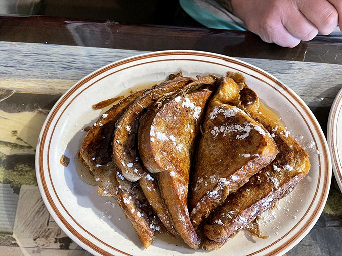 French toast stacked high like golden library books, dusted with powdered sugar&mdash;breakfast that doubles as dessert is always the right choice.