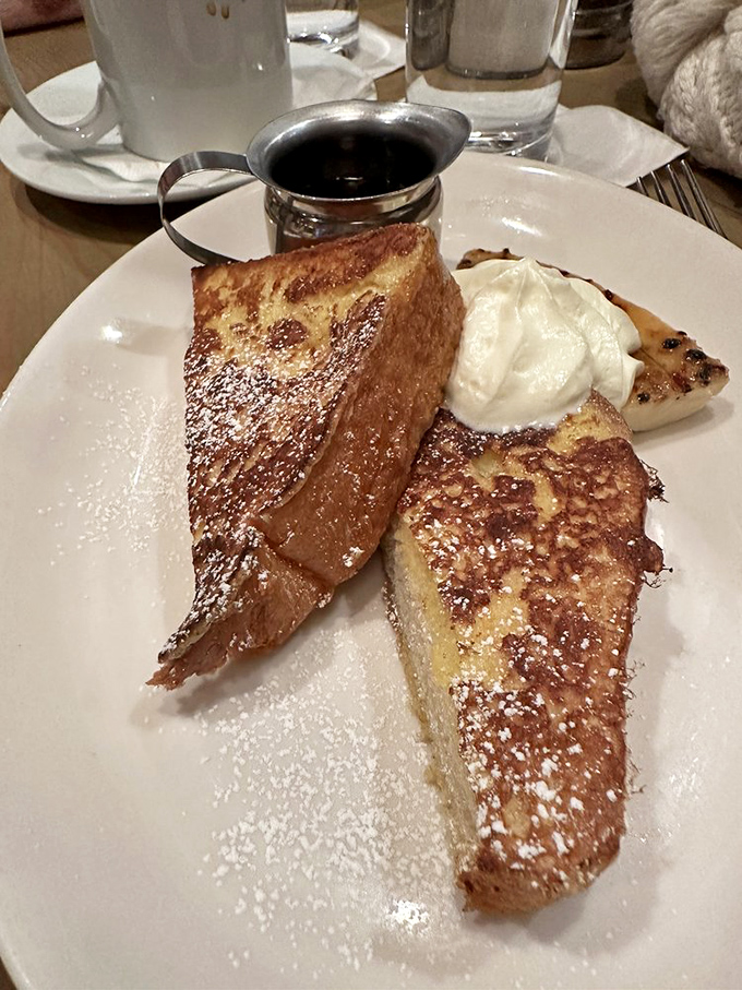 French toast that's dressed for success—golden-brown, powdered with sugar, and ready for its maple syrup baptism.