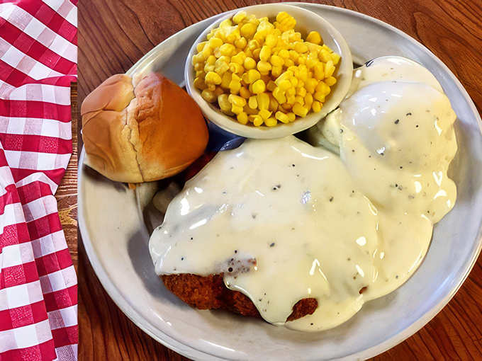 Country-fried steak swimming in pepper gravy with corn playing lifeguard on the side. The kind of plate that demands a nap afterward—and makes it entirely worth it.