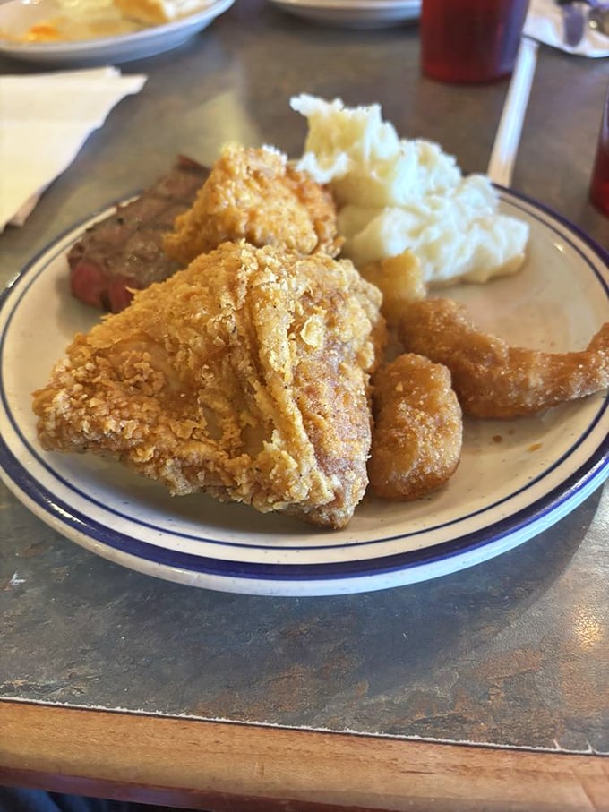 The holy trinity of American comfort: golden fried chicken, savory food, and what appears to be the mashed potato of your childhood dreams.