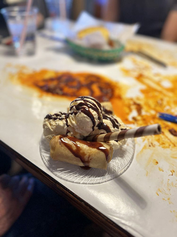 A sweet finale: fried banana with ice cream and chocolate drizzle. Because after wrestling with crab legs, you've earned this moment of simple dessert bliss.
