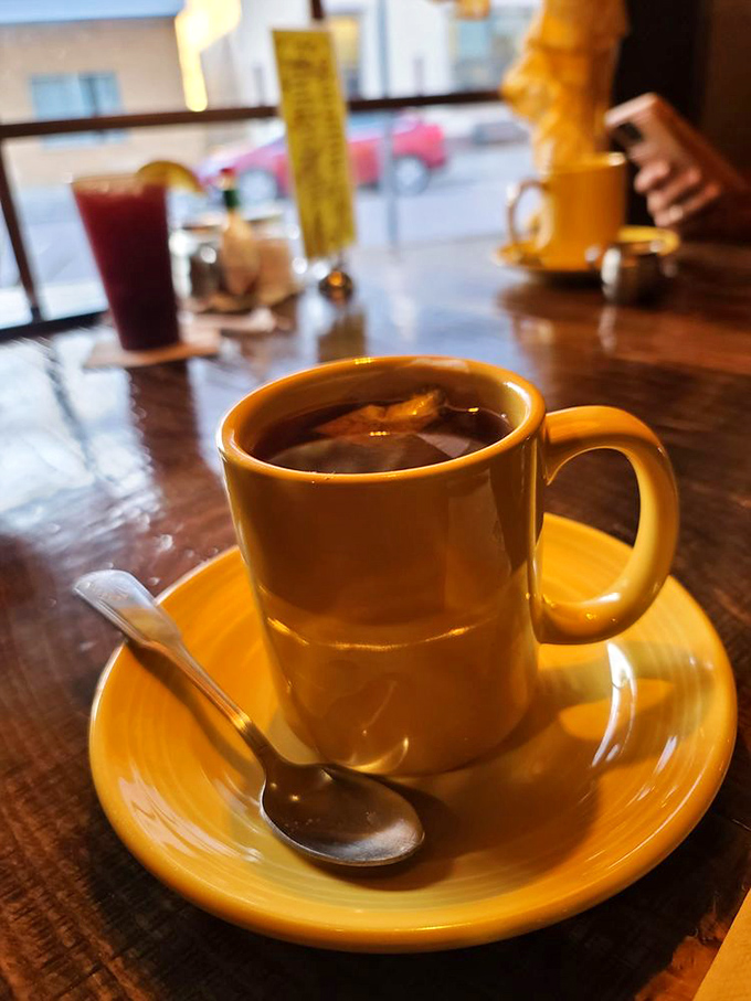 That golden ceramic mug doesn't just hold tea&mdash;it cradles liquid comfort on a wooden table that's seen decades of Tennessee stories.