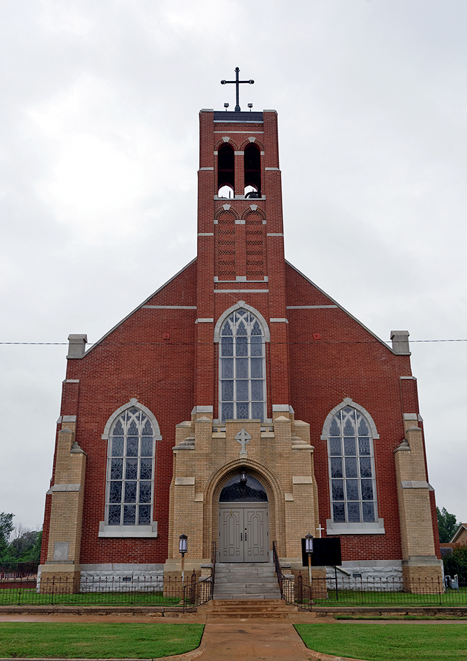 The Immaculate Conception Catholic Church rises in red brick splendor, its Gothic windows framing stained glass that tells the Osage story.