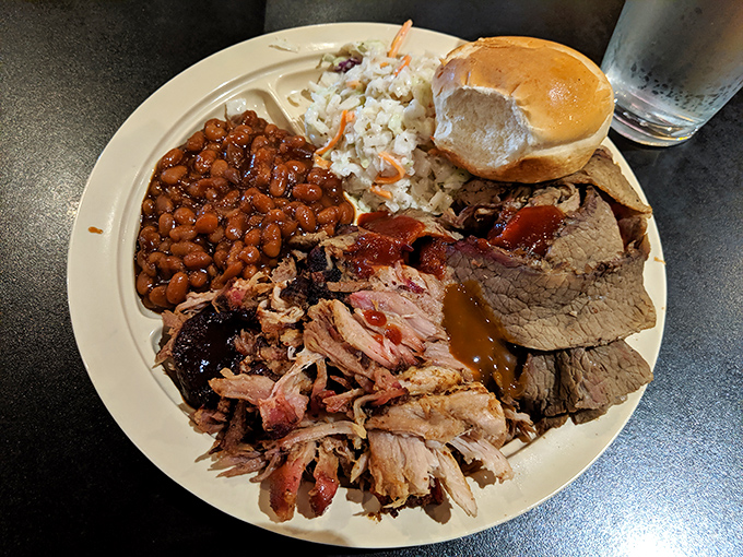 The carnivore's dream team assembled on one plate: pulled pork, sliced brisket, and sides that know their supporting role perfectly.
