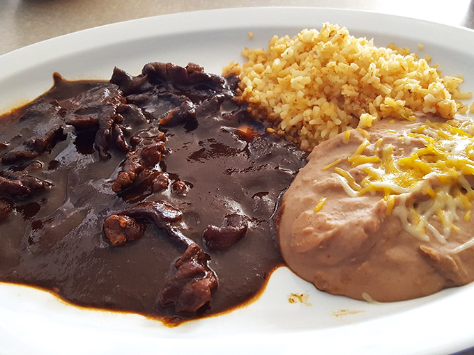 Mole so dark and rich it could finance your retirement, paired with perfectly fluffy rice and refried beans that aren't afterthoughts.
