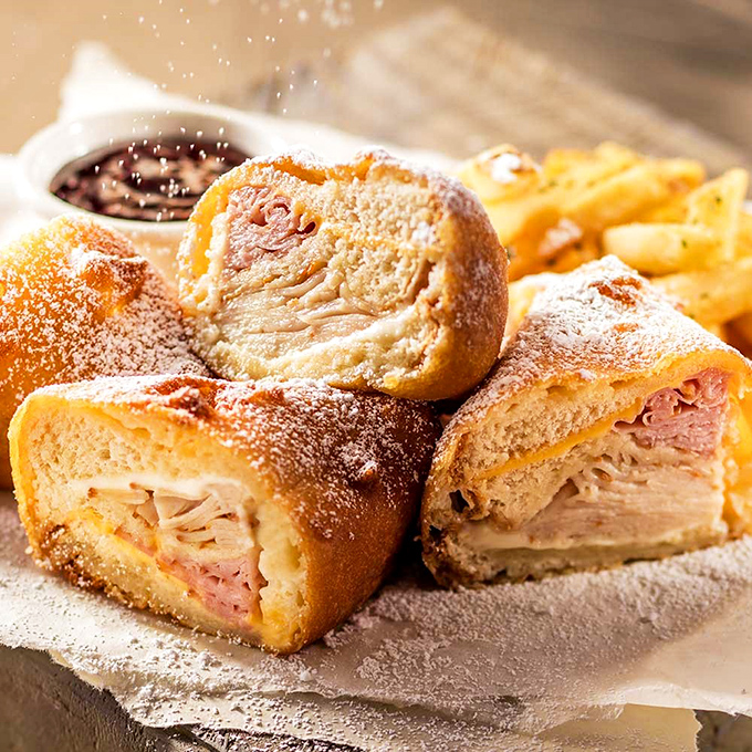 The Monte Cristo: where breakfast and lunch stop fighting and just make out. Powdered sugar, ham, and deep-fried goodness that's worth every napkin.