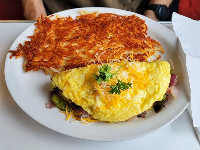 That omelet looks like it's been working out, flexing its protein-packed muscles next to hash browns crisped to golden perfection.
