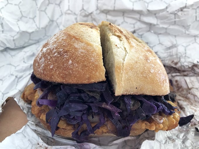 A sandwich that demands to be photographed before eating. Purple cabbage and golden-fried goodness creating edible art on humble foil.