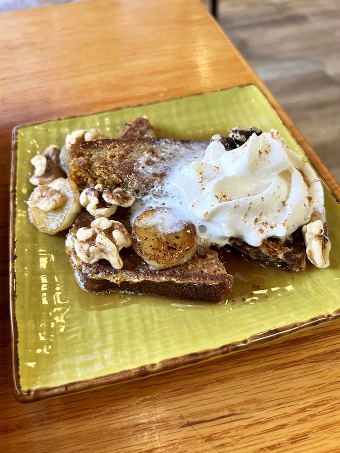Pumpkin bread transformed into French toast—topped with bananas, walnuts, and whipped cream. Dessert masquerading as breakfast, and nobody's complaining.