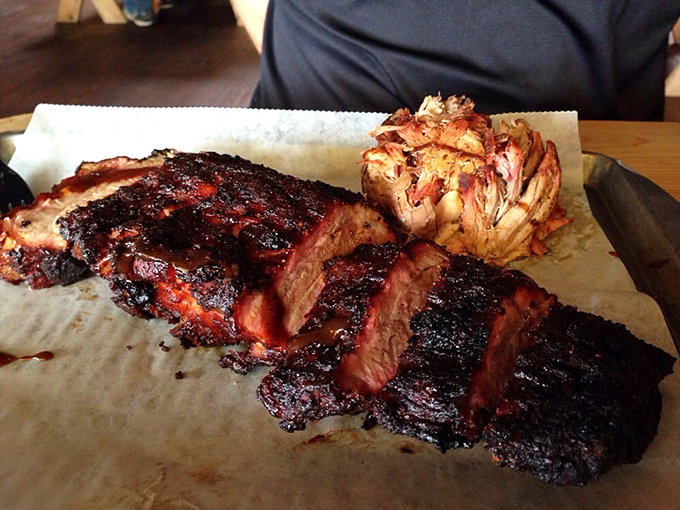 Smoke-kissed ribs with that telltale pink ring sit alongside a garlic knot &ndash; proof that barbecue is both science and soulful art form.