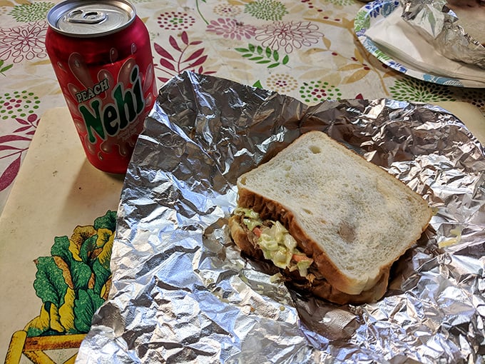The perfect pairing—a cold Nehi peach soda alongside a foil-wrapped sandwich. Some traditions don't need improving, just appreciating.