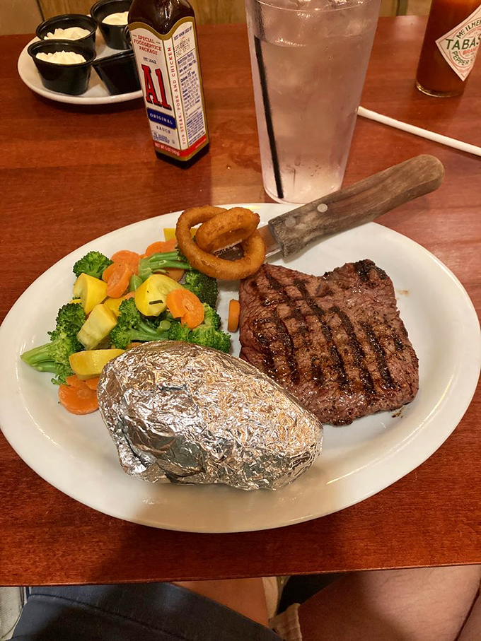 A perfectly grilled sirloin steak with the classic foil-wrapped potato&mdash;like getting a letter from an old friend who still knows exactly what you like.